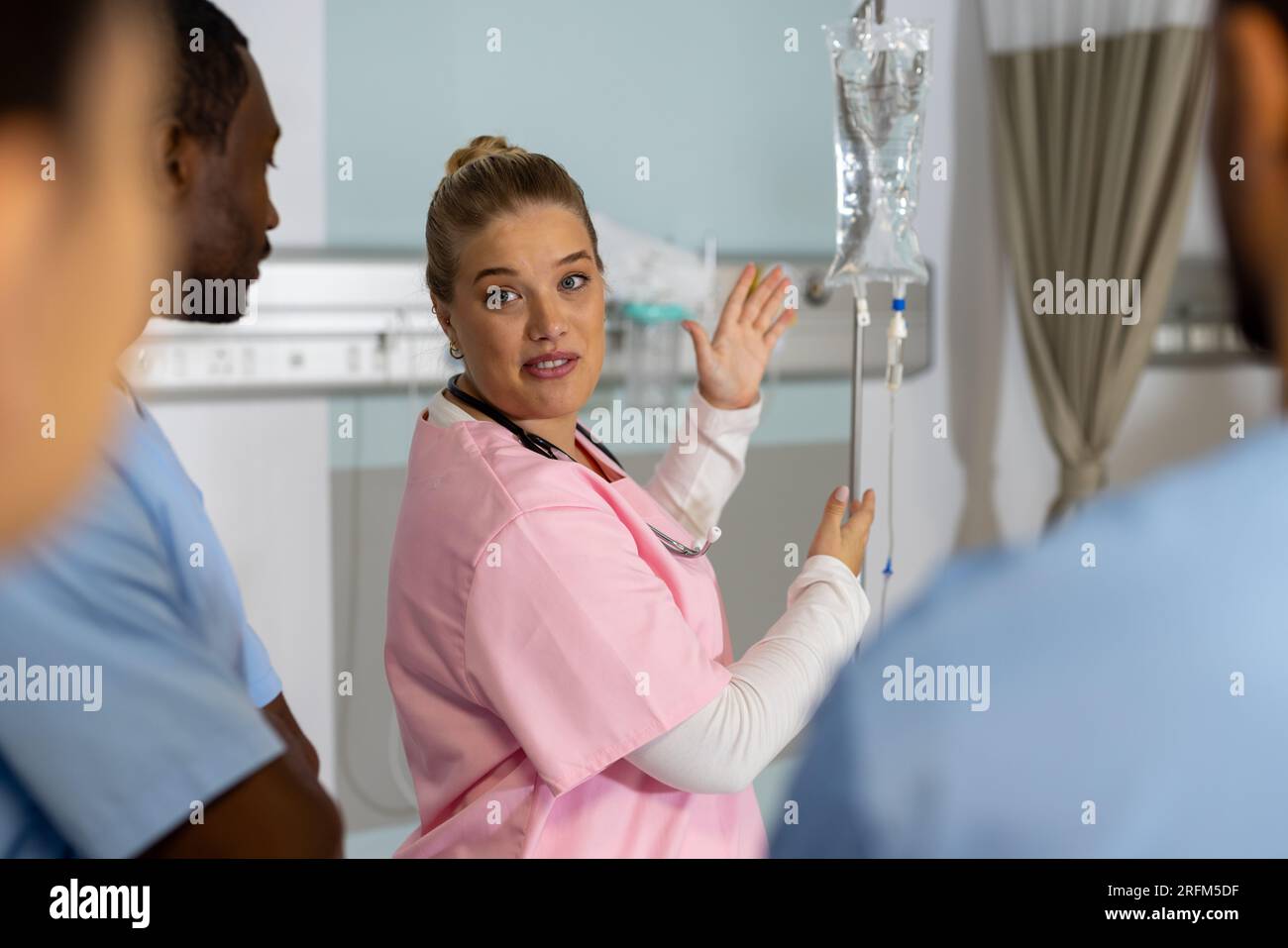 Caucasian female doctor with diverse trainee doctors applying drip at ...