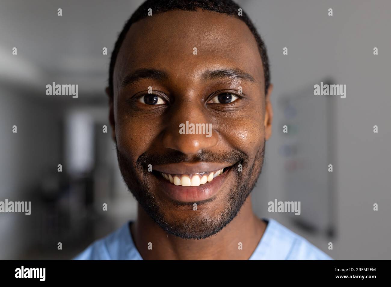 Portrait of happy african american male doctor wearing scrubs in ...