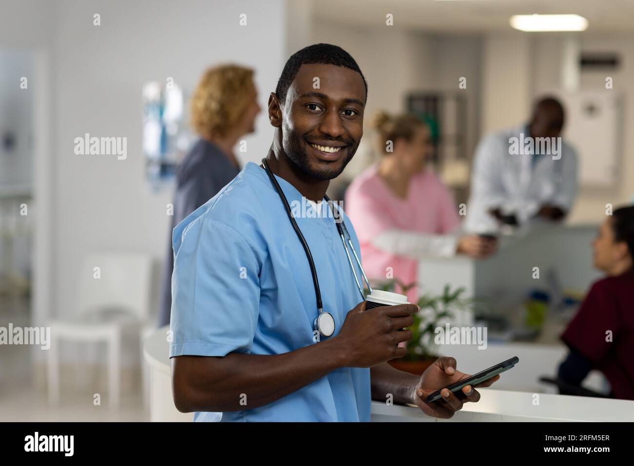 Portrait of happy african american male doctor wearing scrubs at ...