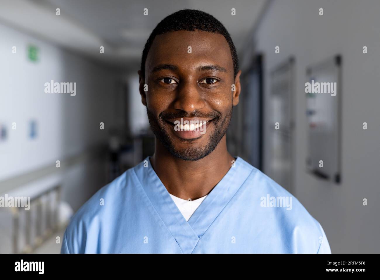 Portrait of happy african american male doctor wearing scrubs in ...