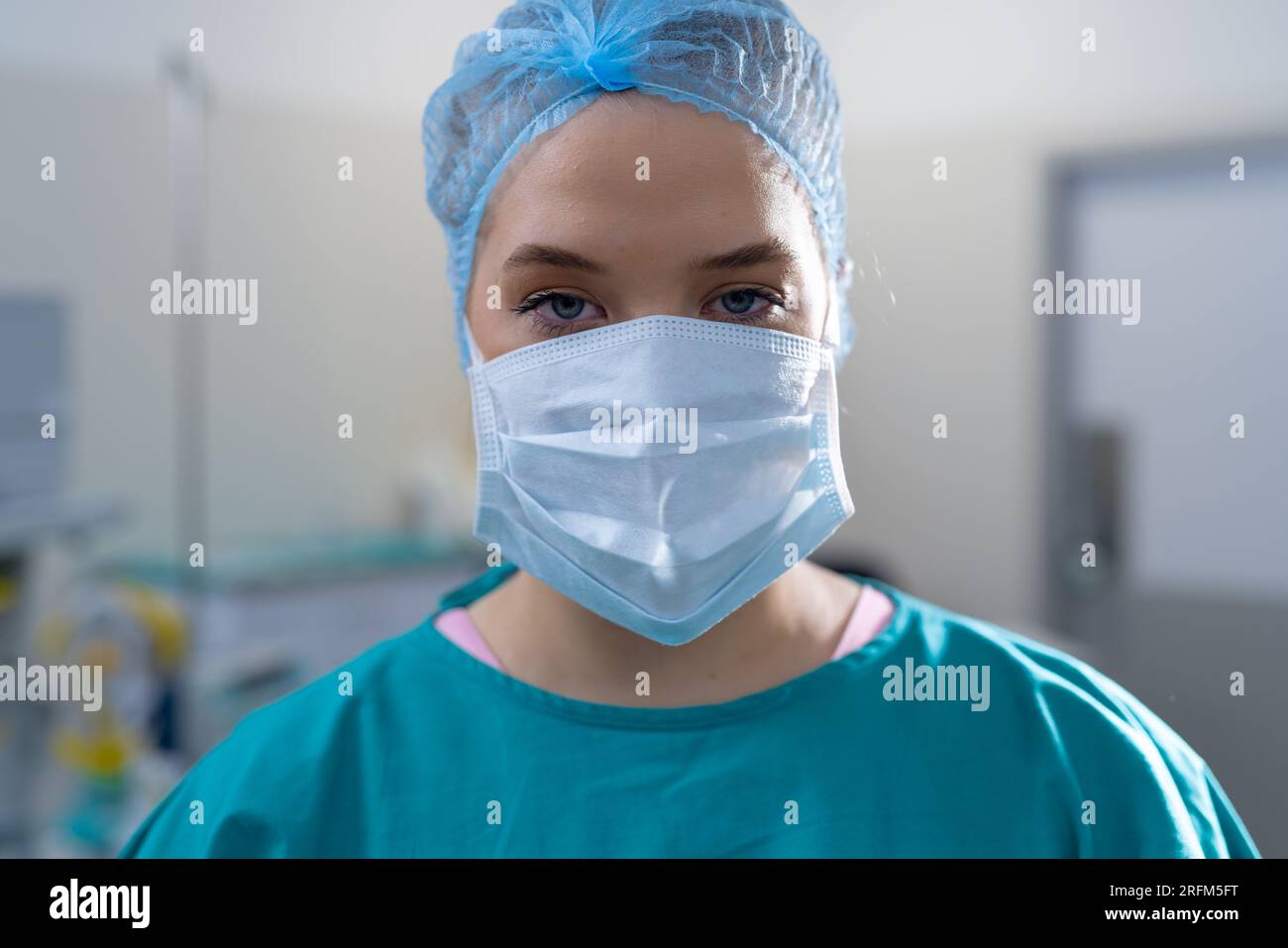 Portrait of caucasian female surgeon wearing surgical gown in operating ...