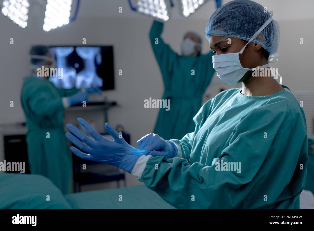 African american female surgeon wearing surgical gown and gloves in ...