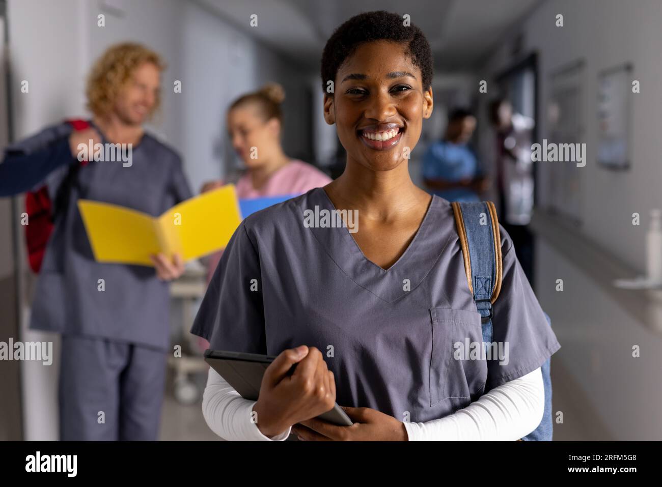 Portrait of happy african american female doctor wearing scrubs with ...