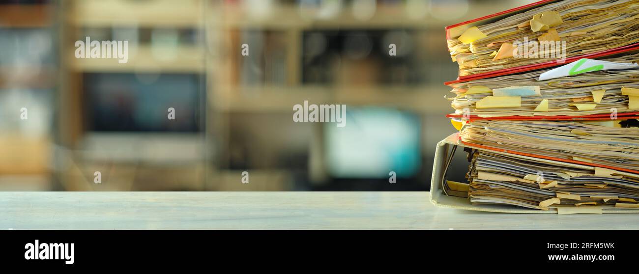 stack of dusty messy file folders with narrow depth of field, blurred ...