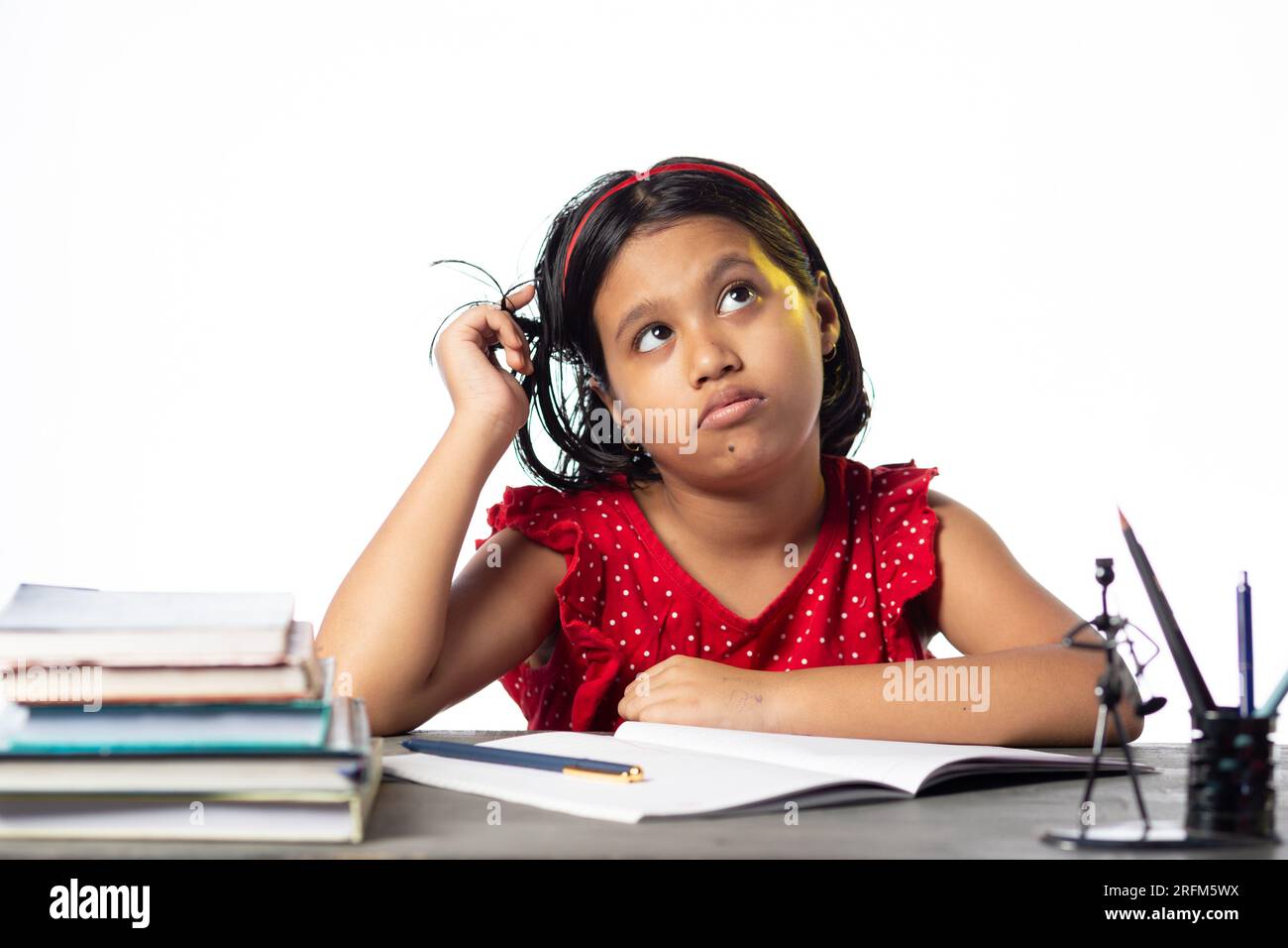 A pretty beautiful Indian girl child thinking and looking upwards while ...