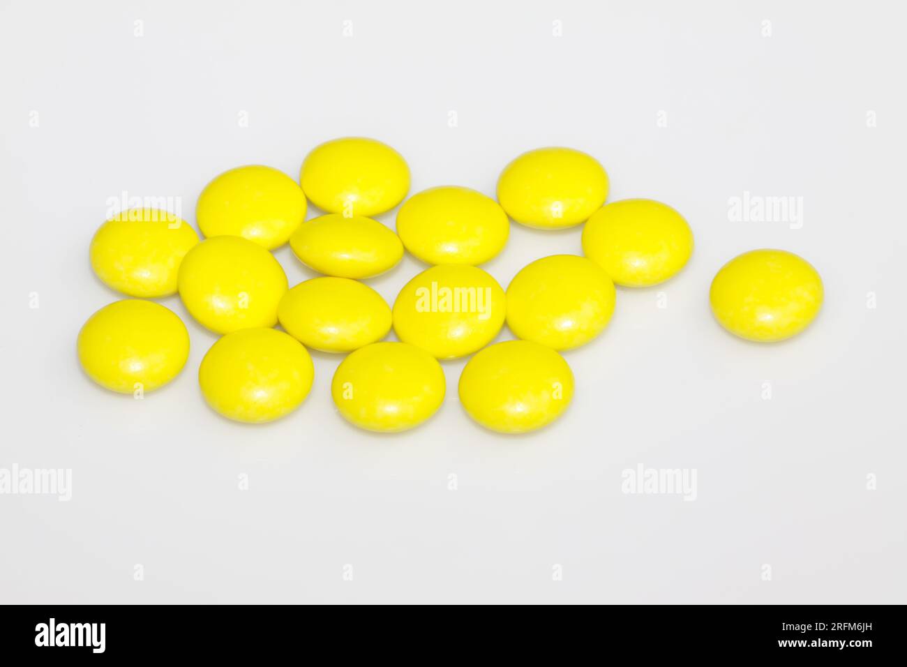 yellow tablet drug on a white background Stock Photo - Alamy
