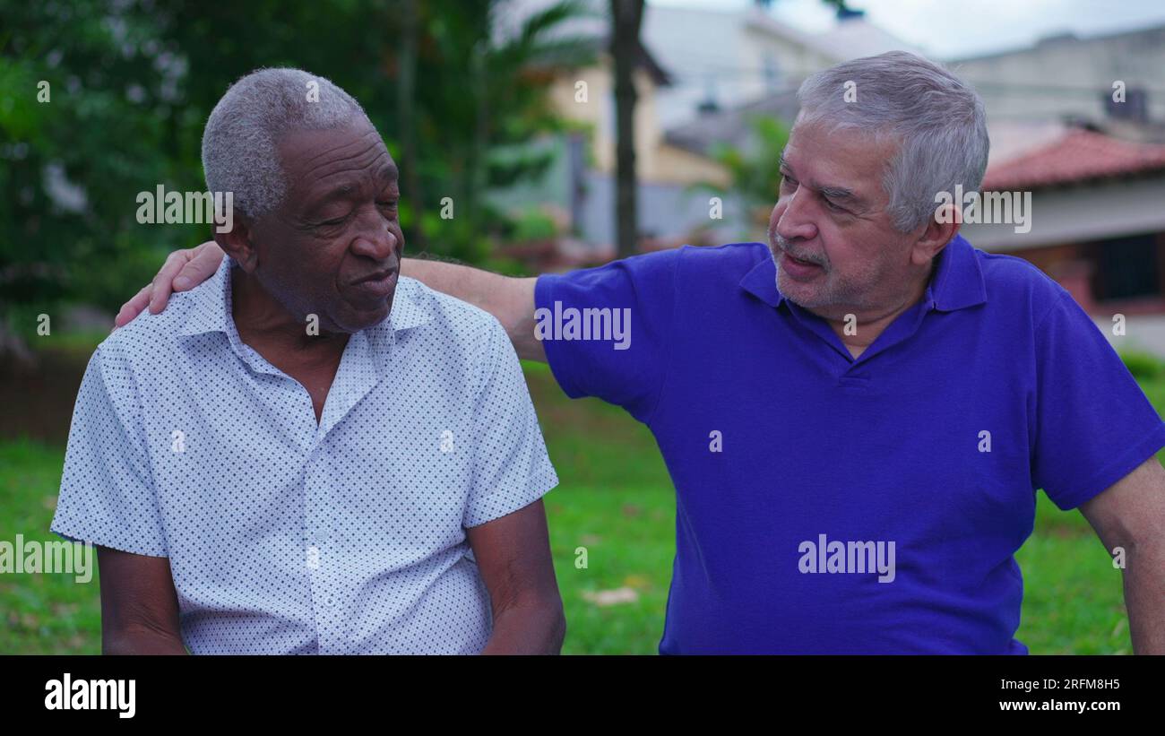 Two diverse senior friends sharing moment of camaraderie sitting on ...