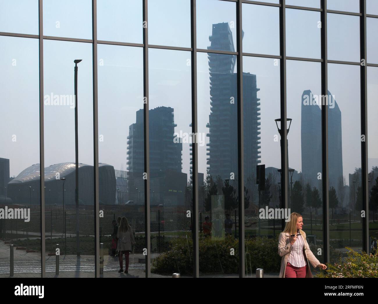 businesswoman outside a glass panels office building reflecting modern ...