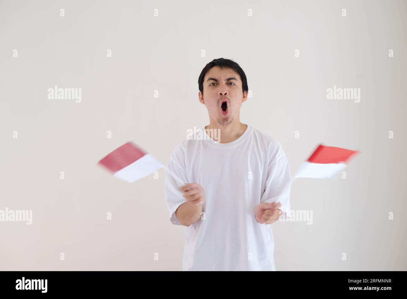 A man wearing white T-Shirt is waving Bendera Indonesia or Indonesian ...