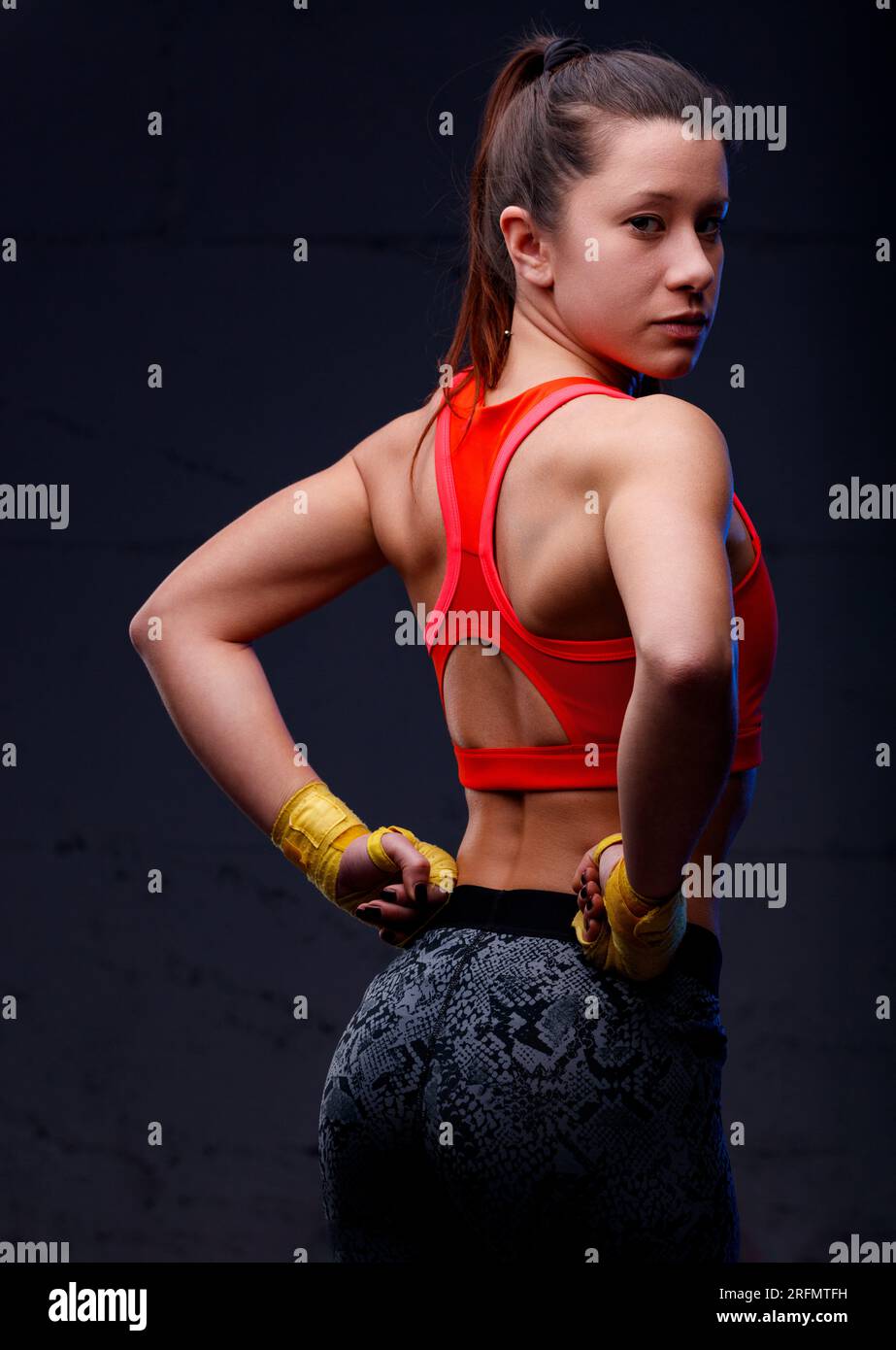 Kick-boxing woman, proud of her muscular back and firm body. Embraces ...