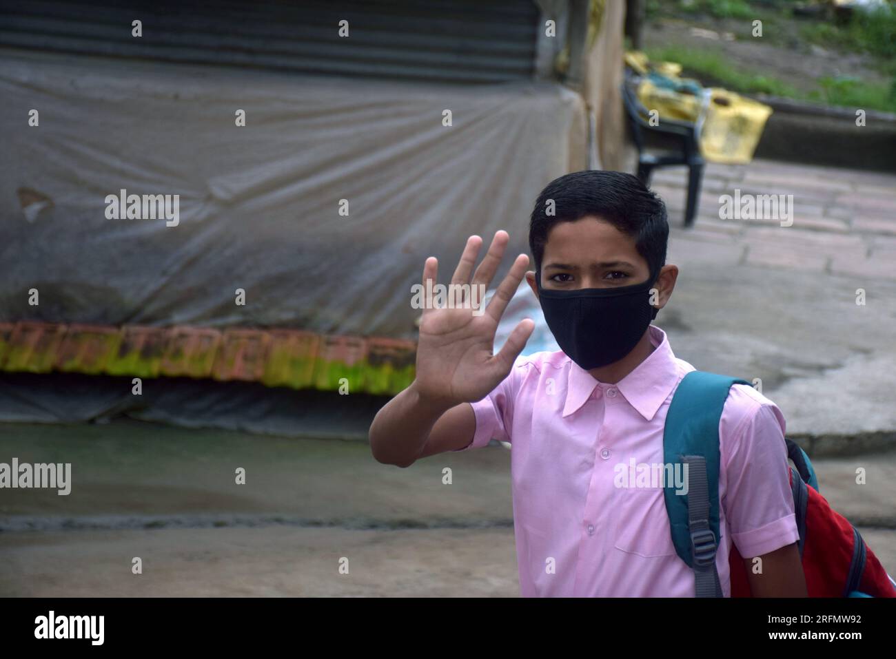 teen student boy wearing school uniform and face mask going to school ...