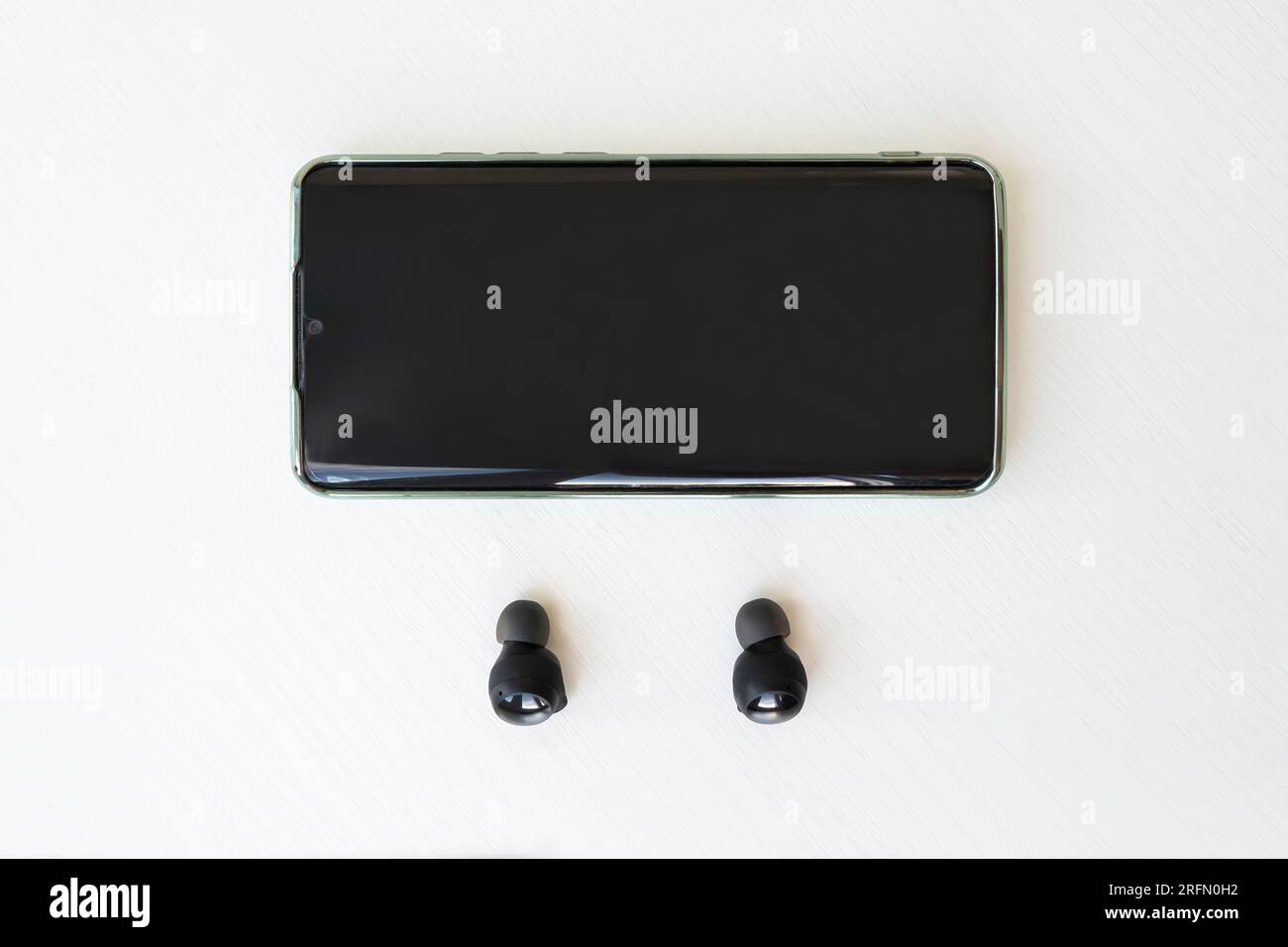 Smartphone and wireless headphones or earbuds top view Music technology ...