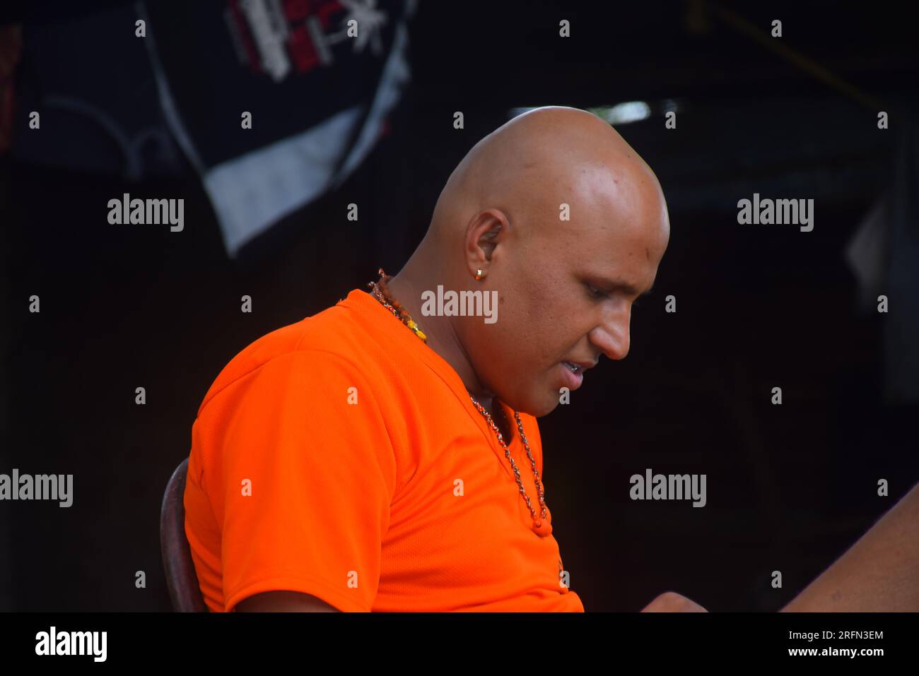 cute bald model wearing orange t-shirt, smiling looking at the camera ...
