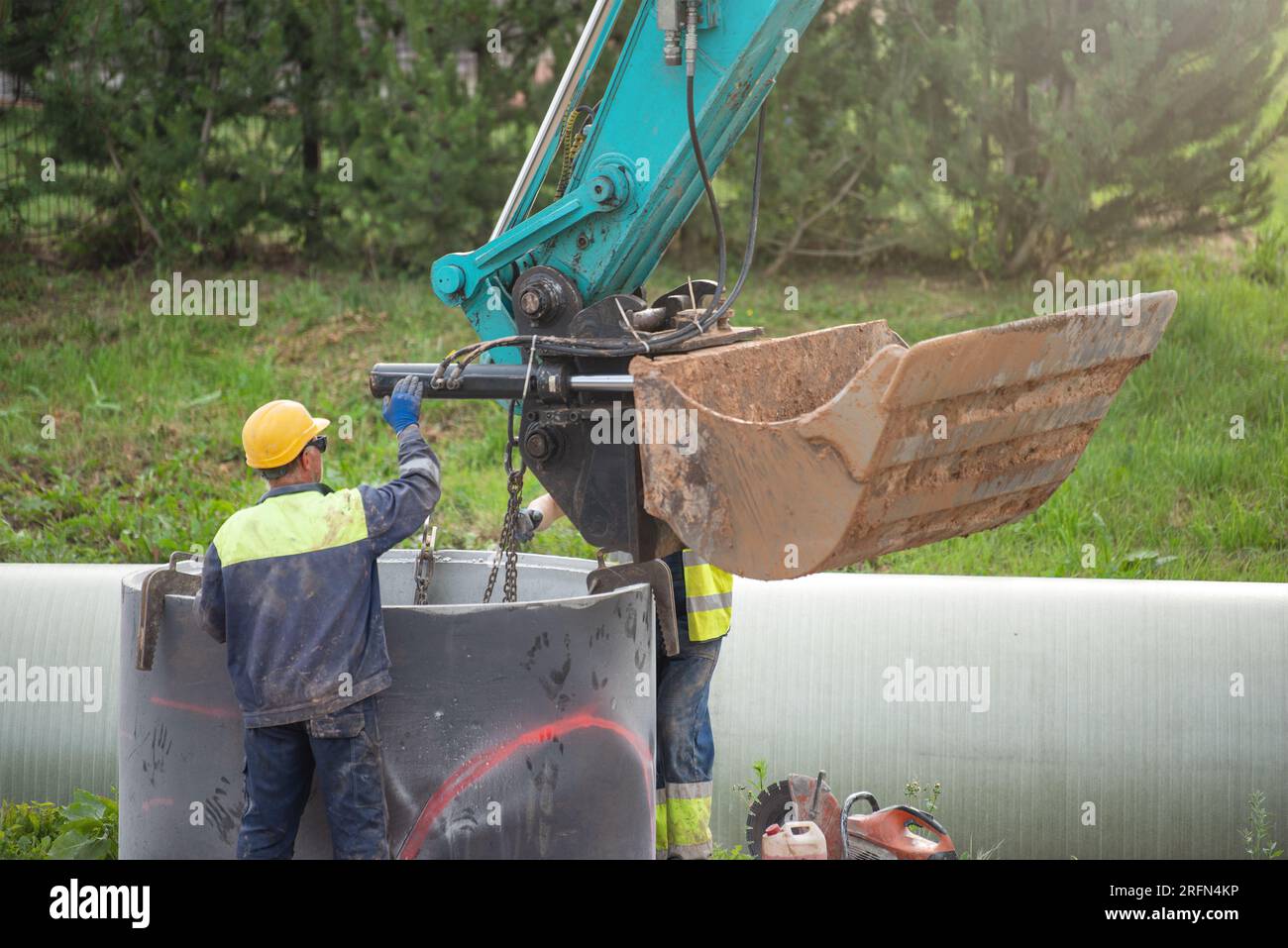 Workers are working on the construction site. An excavator uses a chain ...