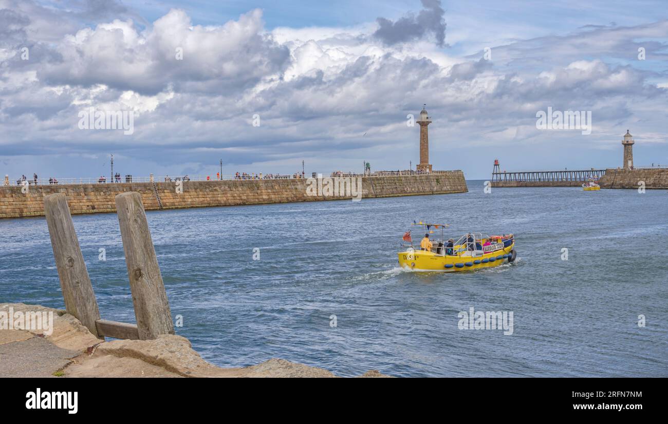 Whitby harbour entrance. Two lighthouses stand at the end of each pier ...