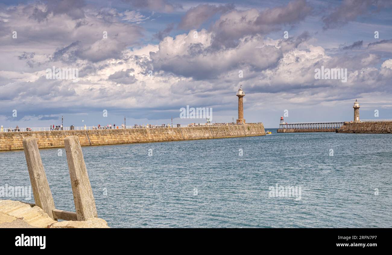 Whitby harbour entrance. Two lighthouses stand at the end of each pier ...