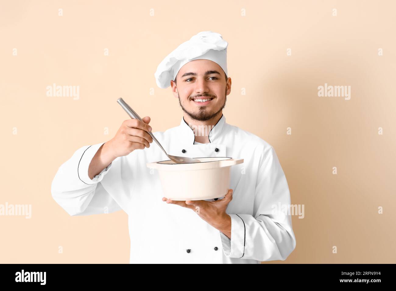 Male chef with ladle and cooking pot on beige background Stock Photo ...