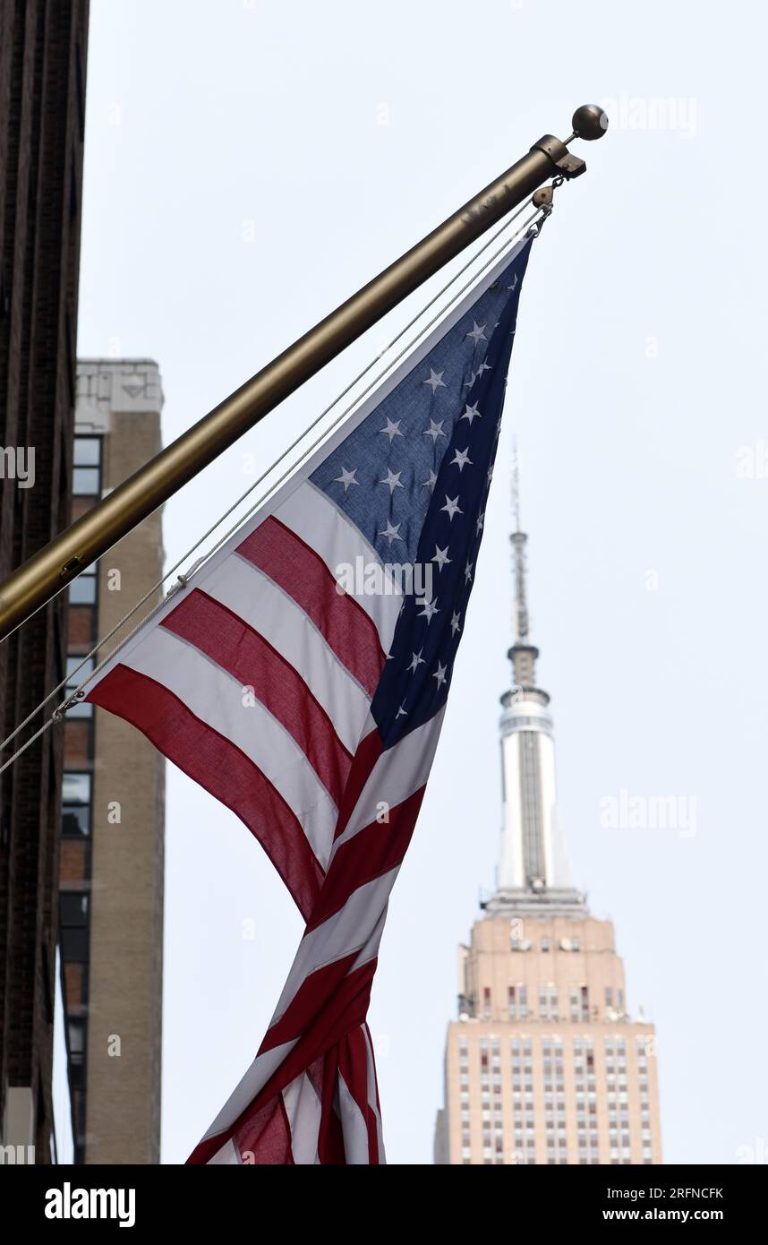 A twisted American stars and stripes flag hangs in front of the Empire ...