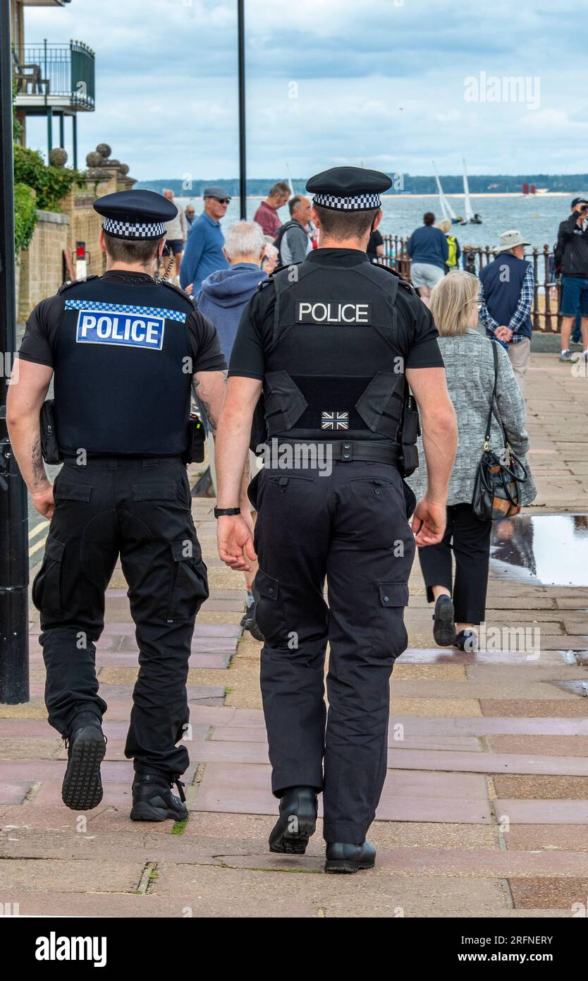 two young police officers patrolling on foot. two policemen walking ...