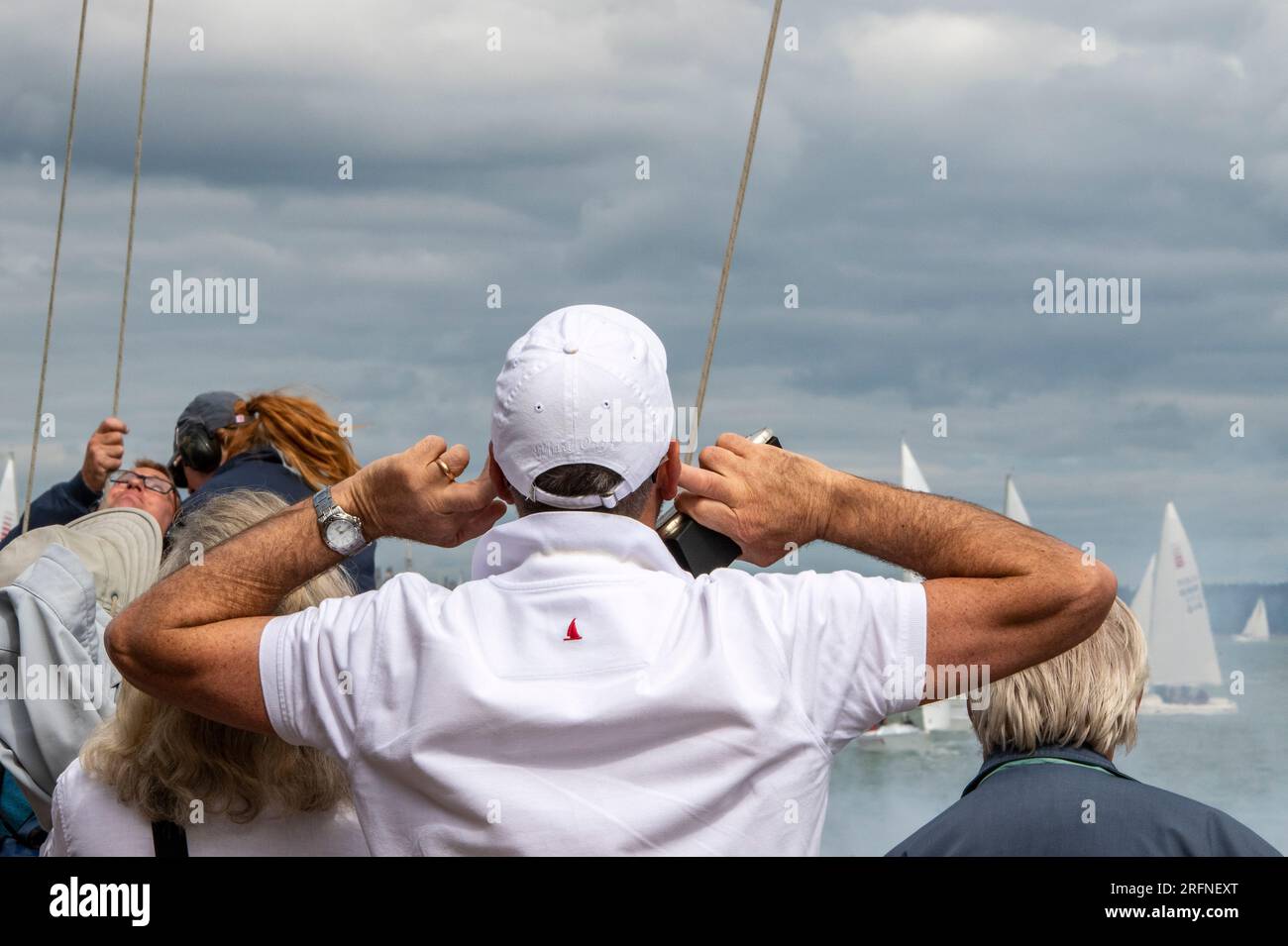 man with fingers in his ears to protect them from bang of the starting ...