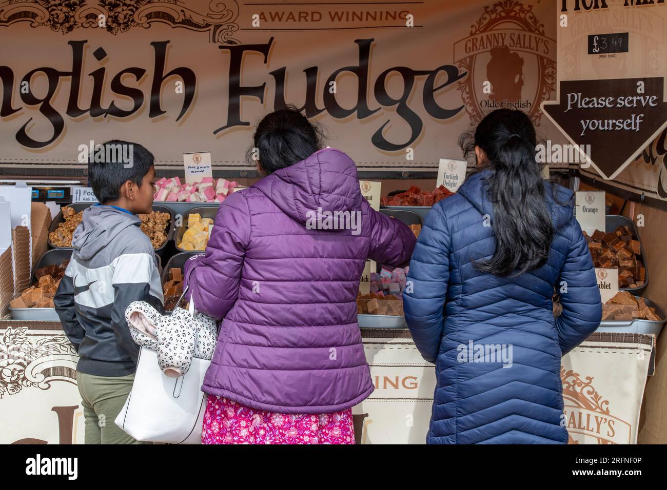 asian family buying fudge from a fudge stall at a market in cowes on ...
