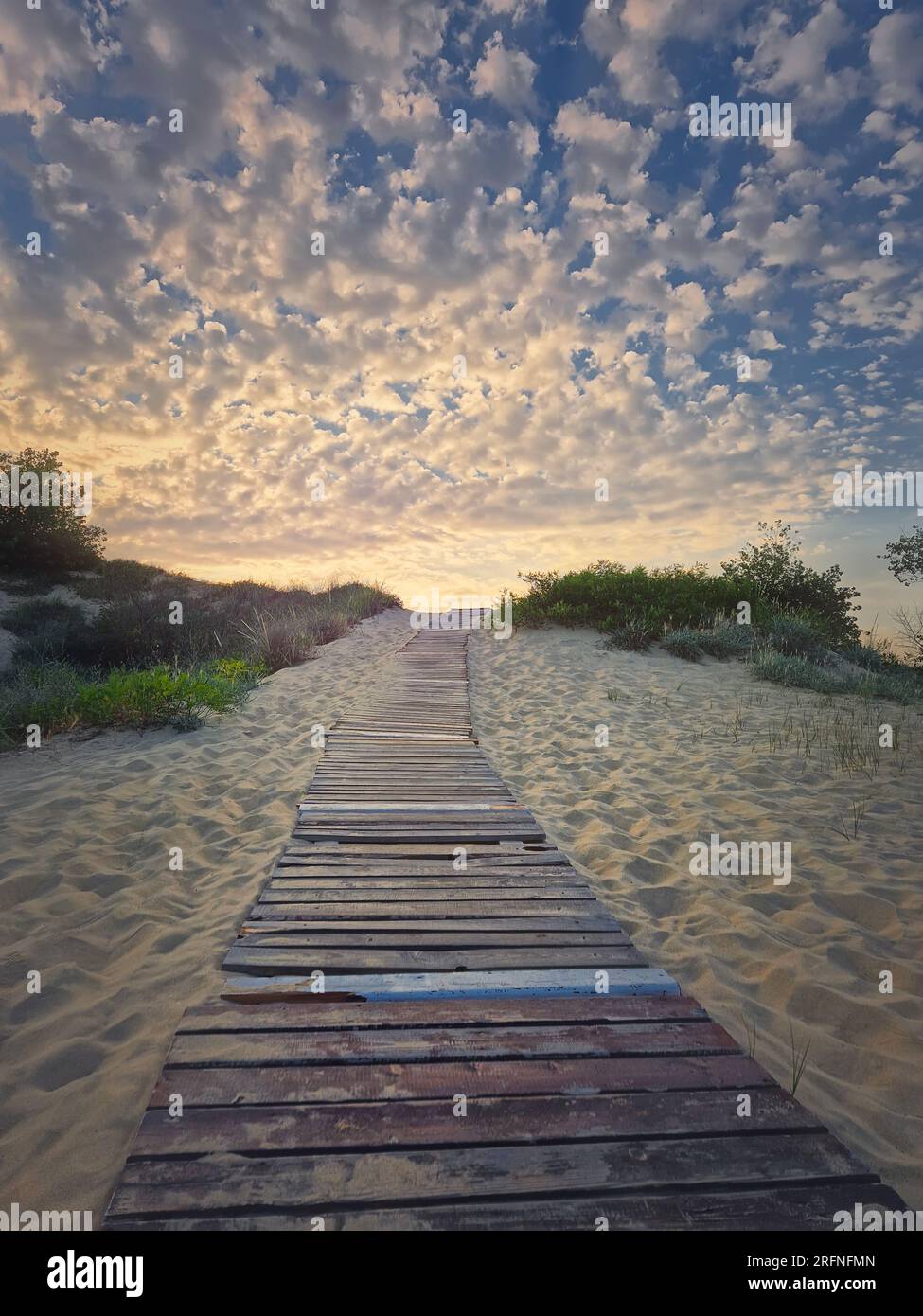 Wooden pathway through the sand leading to the beach and a beautiful ...