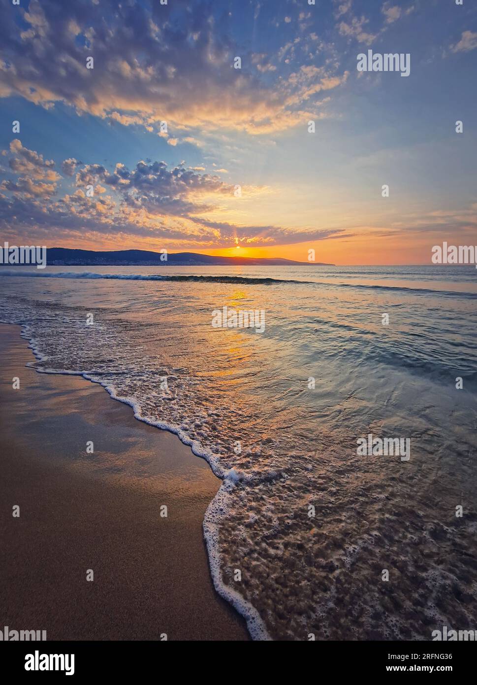 Early morning on the beach with a peaceful view to the sunrise above ...