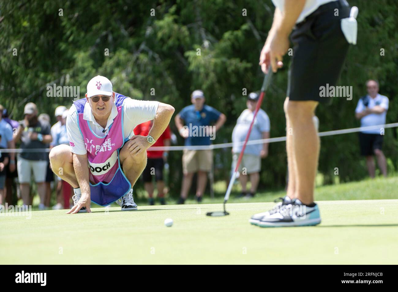 Mal Baker, caddie for Talor Gooch of RangeGoats GC, helps line up a putt on the second green ...