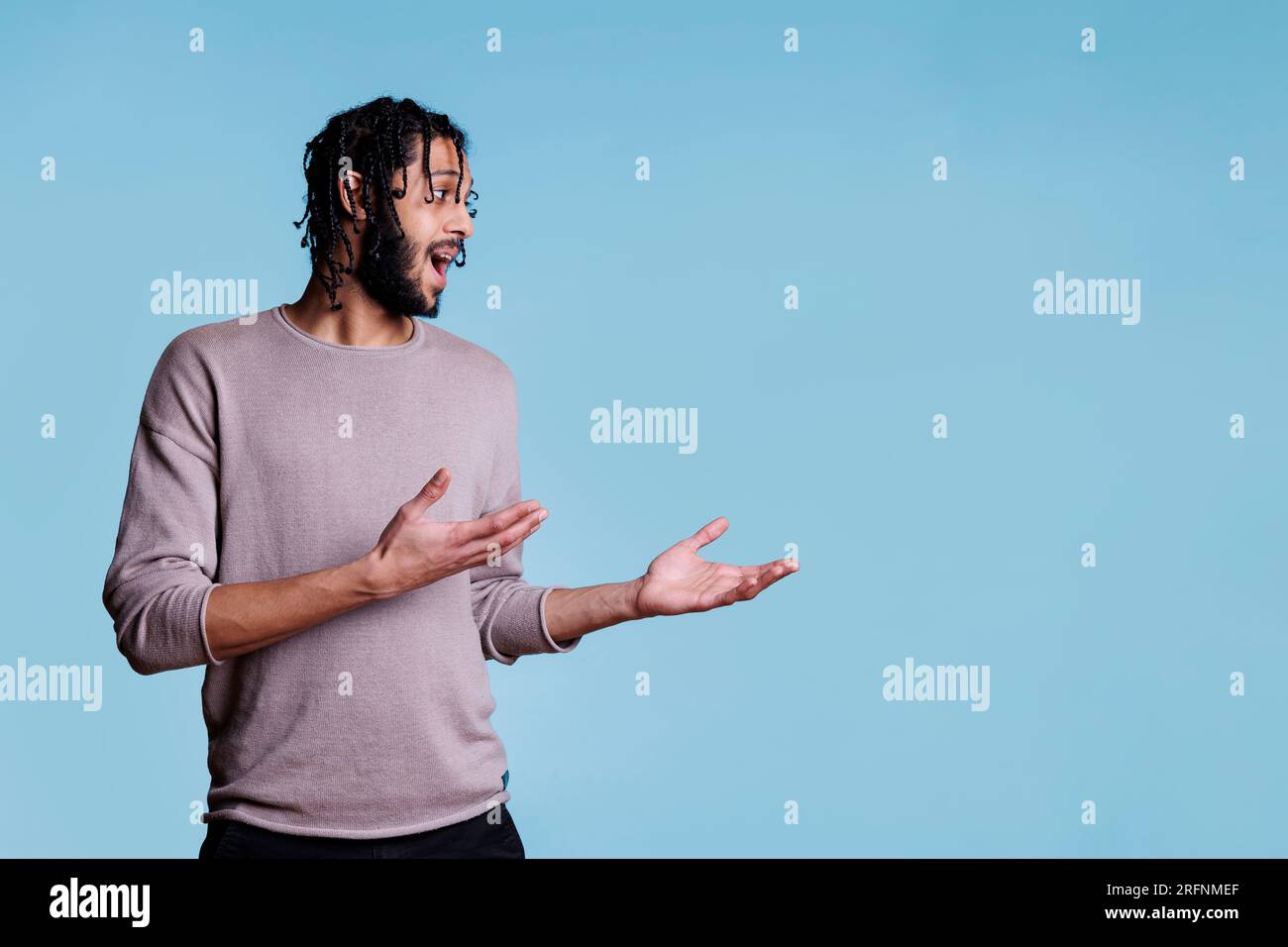 Arab man pointing with hands to side while talking and advertising ...