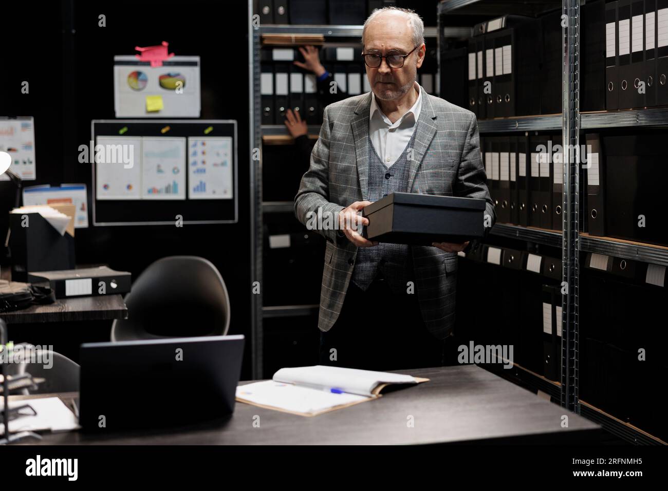 Elderly businessman accountant storing quarterly revenue paperwork ...