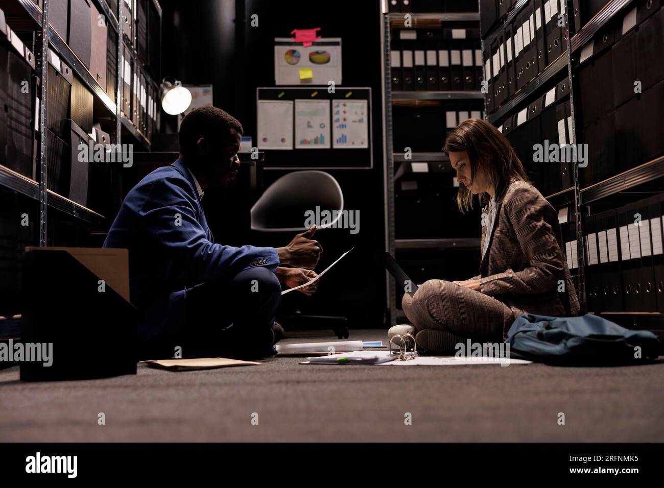 Police Officers Sitting On Floor Analyzing Crime Scene Evidence