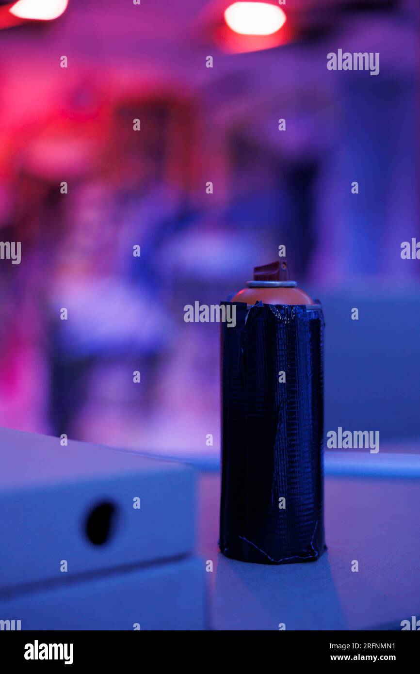 Graffiti spray paint bottles glowing under neon lights, aerosols cans ...