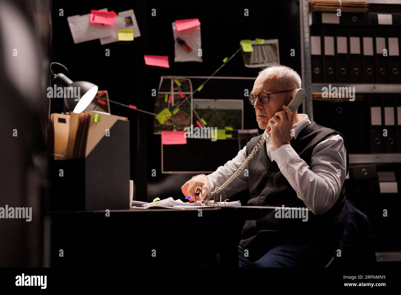 Police officer talking at landline phone with remote inspector ...