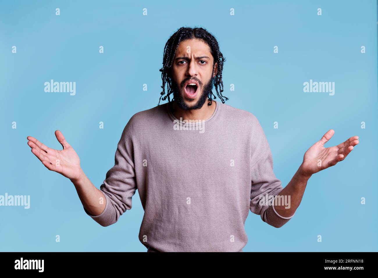 Arab man with open arms and angry facial expression looking at camera ...