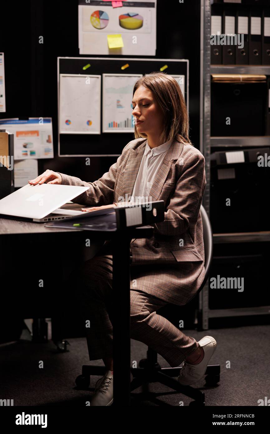 Police officer closing laptop computer after finising work in evidence ...