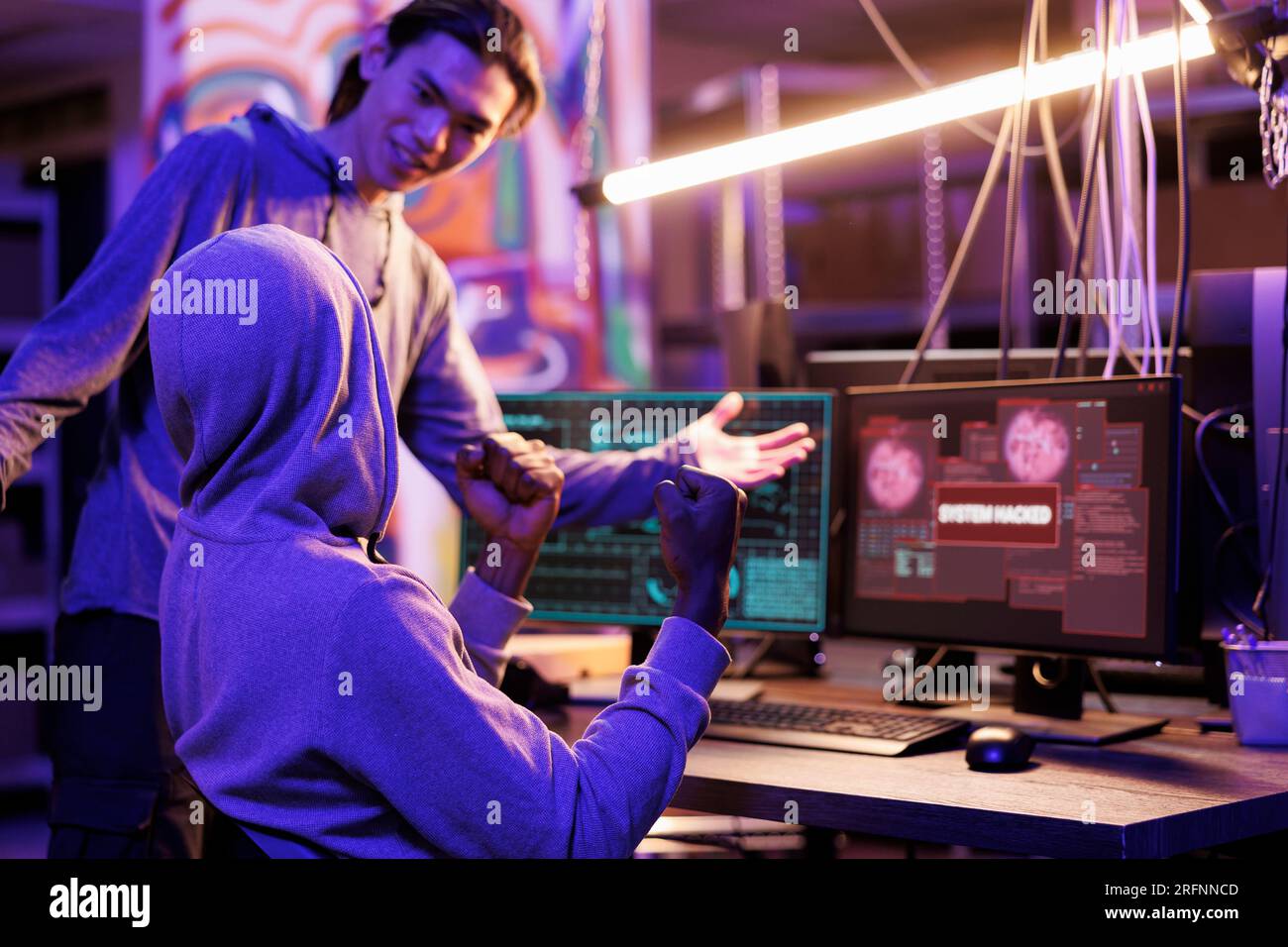 Smiling criminals hacking database and showing victory gesture after ...