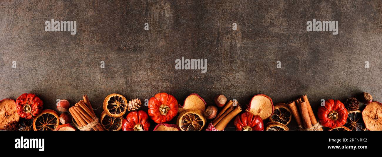 Autumn baking spices and ingredients. Bottom border on a dark stone ...