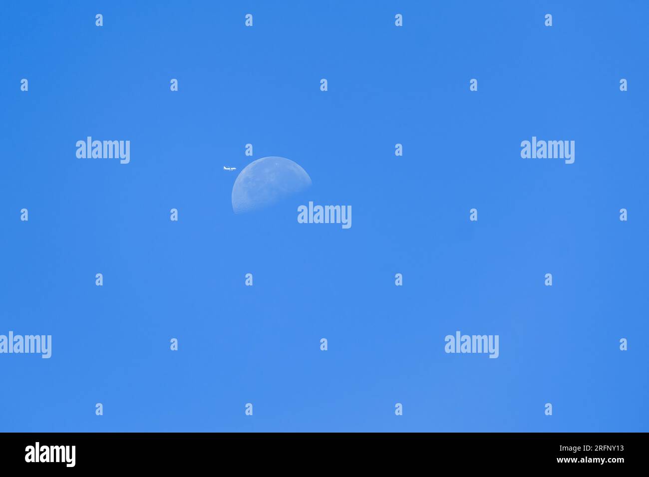 Daily Moon phase with plane in the blue sky Stock Photo - Alamy