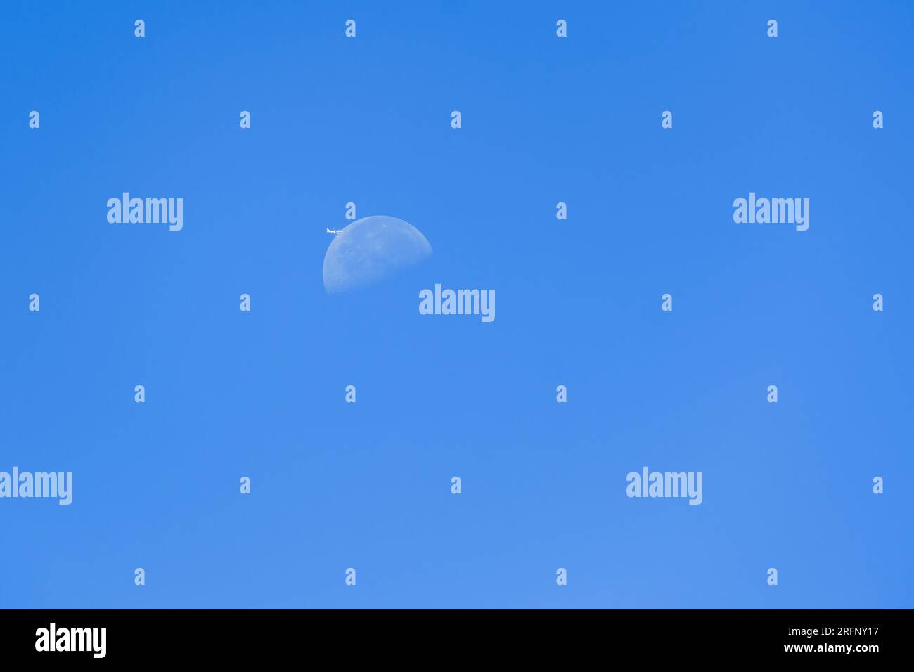 Daily Moon phase with plane in the blue sky Stock Photo - Alamy