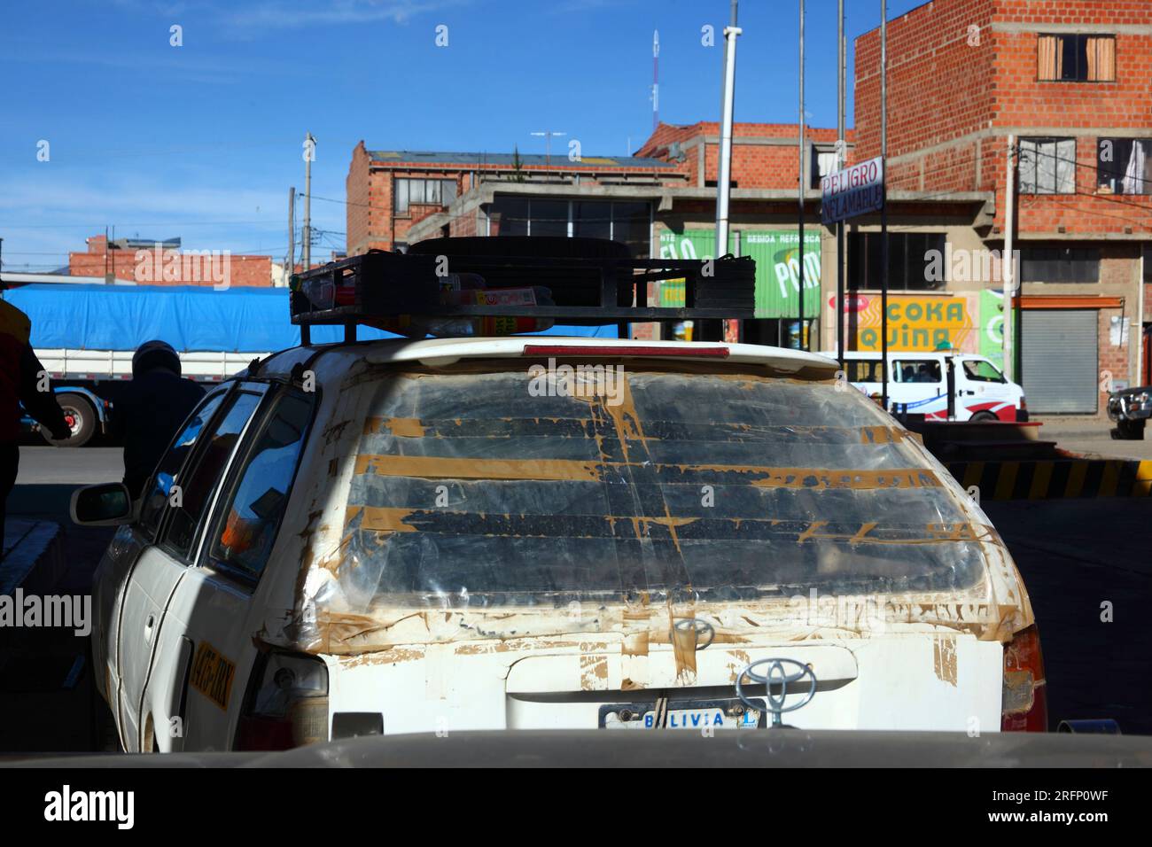 White Toyota taxi with rear window replaced by clear plastic sheet and ...