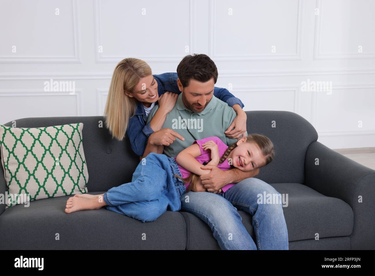 Happy family having fun together on sofa at home Stock Photo - Alamy