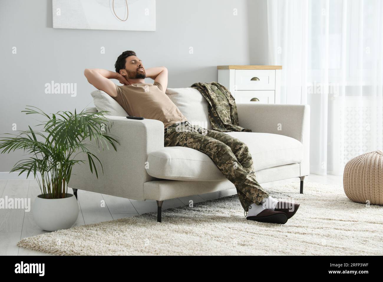 Soldier napping on soft sofa in living room. Military service Stock ...