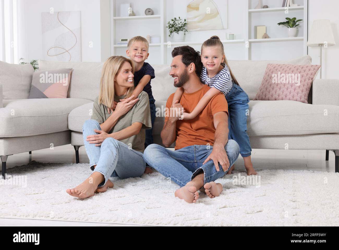 Happy family spending time together on soft carpet at home Stock Photo ...