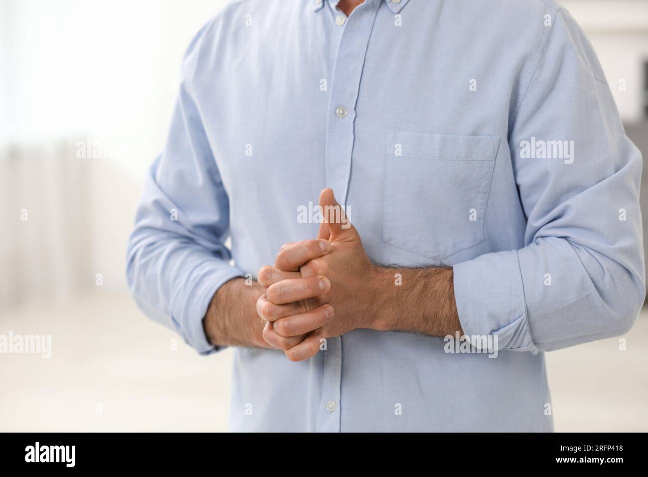 Man cracking his knuckles on blurred background, closeup. Bad habit ...