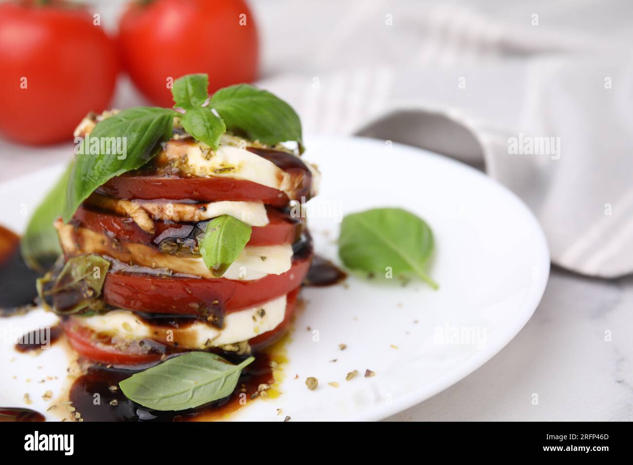 Stacked Caprese salad with balsamic vinegar on table, closeup. Space ...