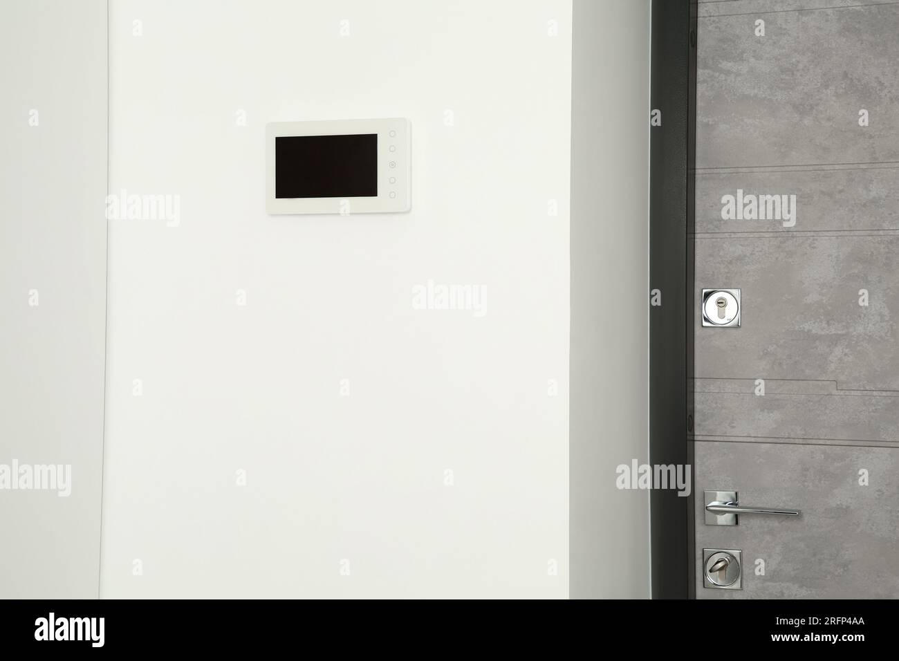 Modern video intercom on white wall near door Stock Photo - Alamy