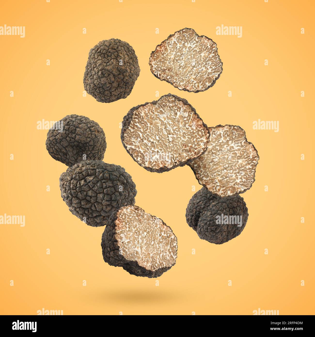 Cut and whole truffles falling on golden background Stock Photo - Alamy