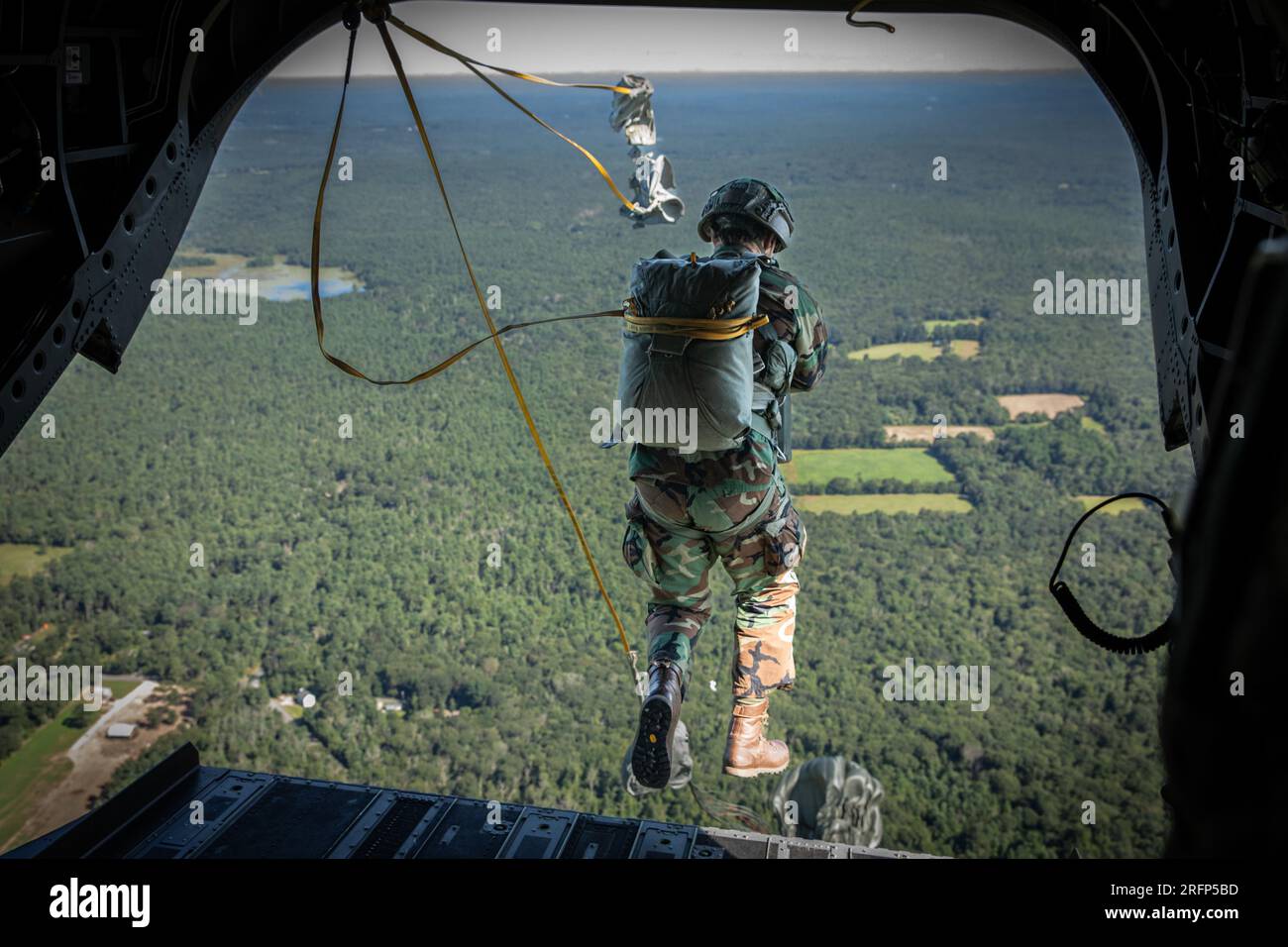 An International Paratrooper performs a static line airborne jump out ...