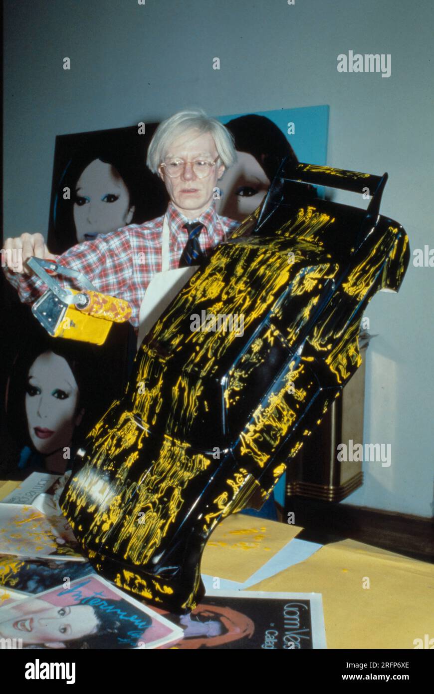 Andy Warhol paints a model car in a performance in New York in 1978 ...