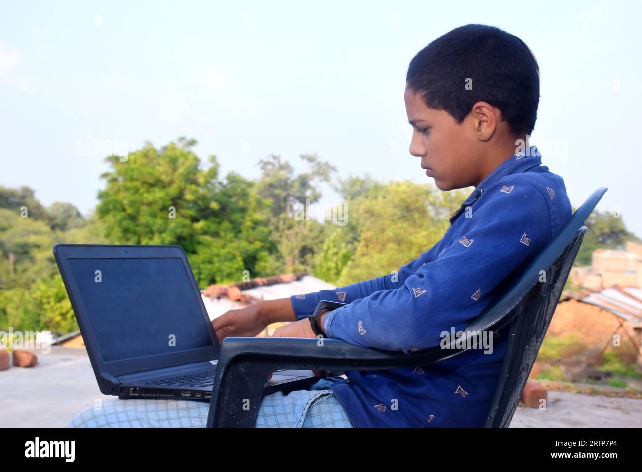 Teen handsome student using laptop. Cheerful boy studying online on ...